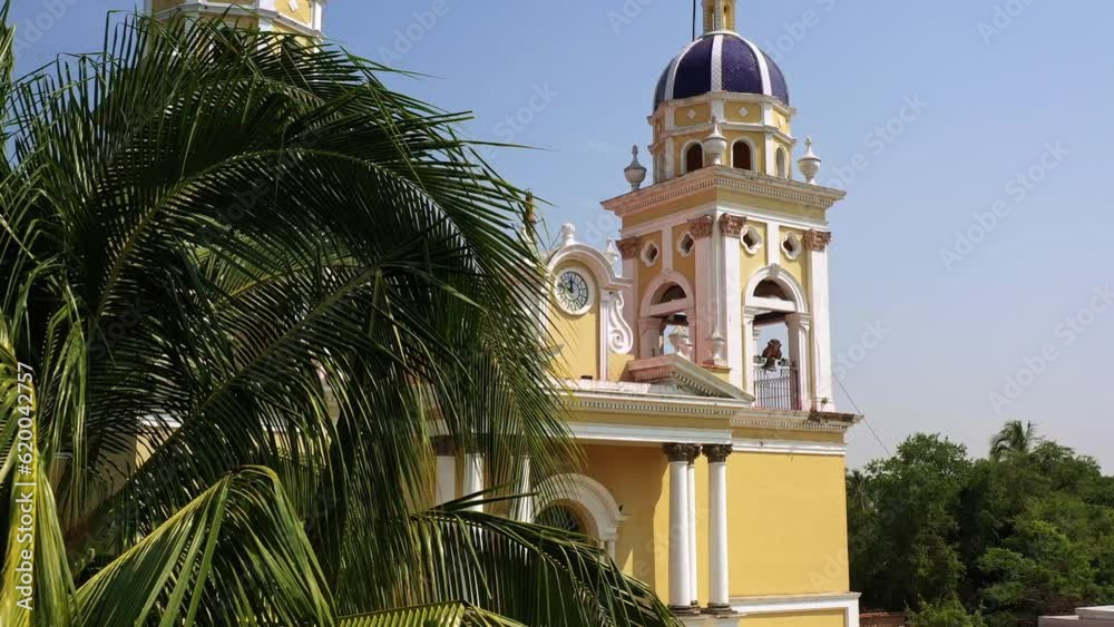 Toma aérea que inicia en una plamera que va descubriendo la fachada de ...
