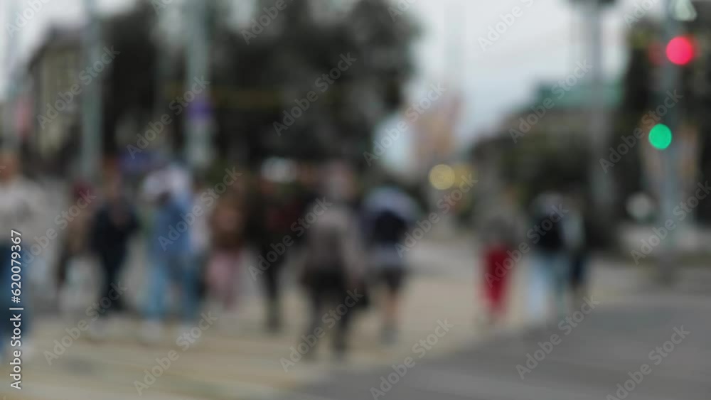 blurry crowd of people crosses a city highway on a pedestrian crossing ...