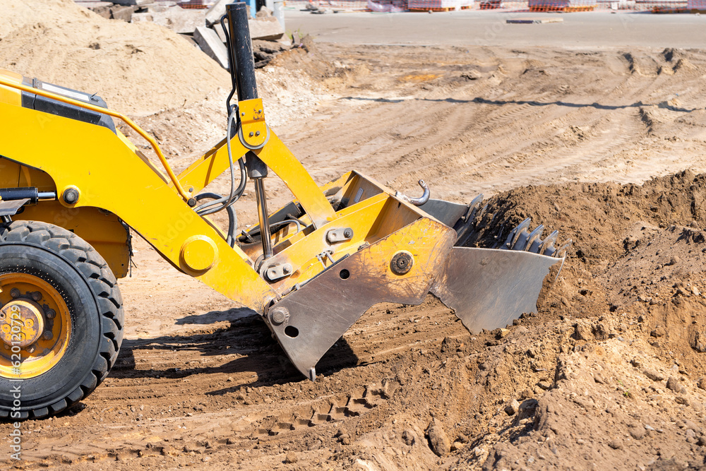 The hydraulic mechanism of the metal bucket of a wheeled bulldozer at ...