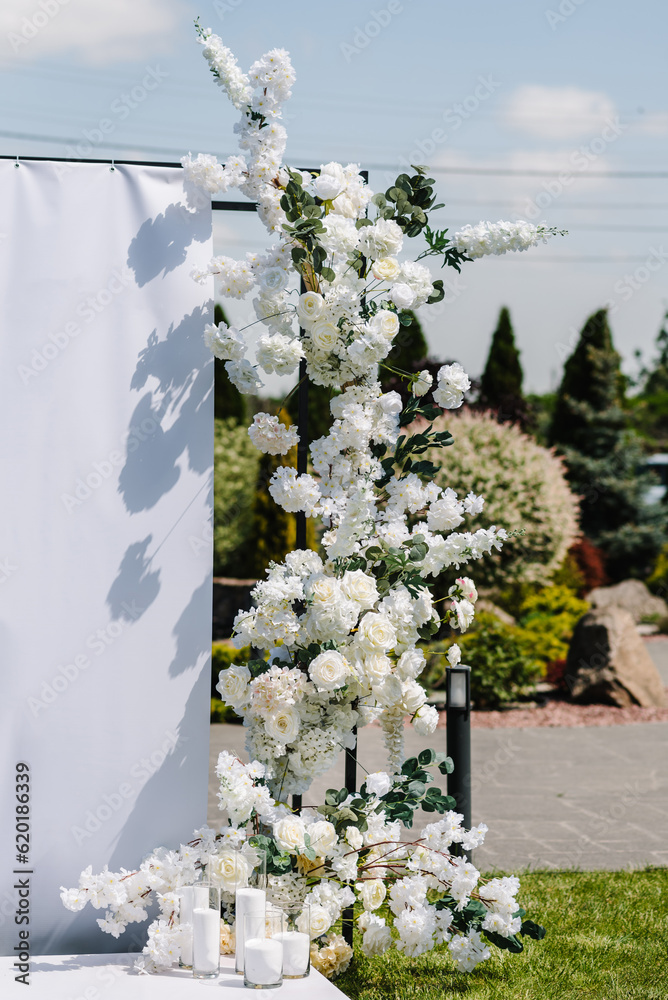 Arch decorated white flowers, greens, greenery, candles. Decor details ...