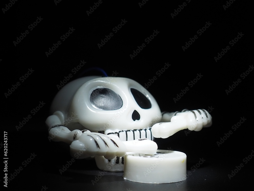 Skull with drumsticks and drum. Terrible clockwork toy. The skeleton is ...