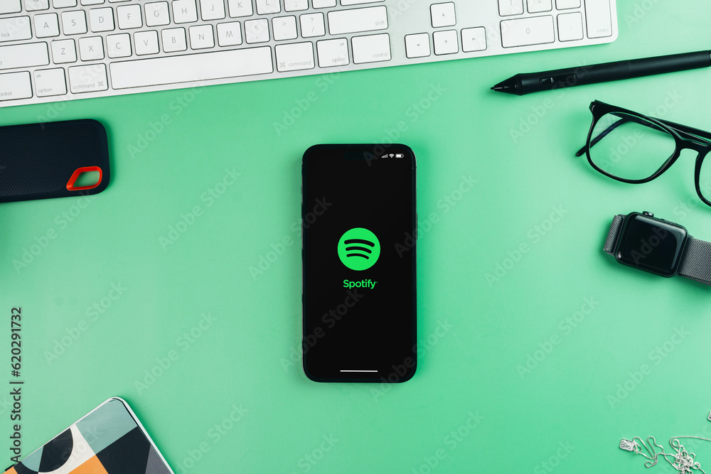 Spotify music app on the smartphone iPhone 14 Pro screen on green table ...