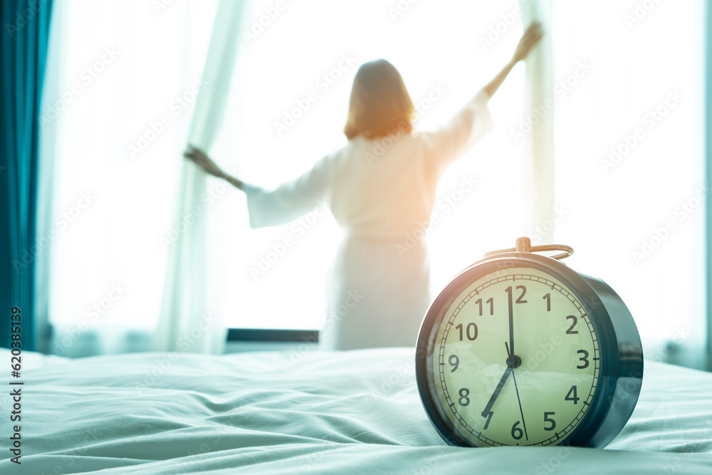 Morning of a new day, alarm clock wake up woman sitting in the room. A ...