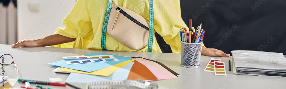 Smiling African-American teacher leans onto table with color palettes ...