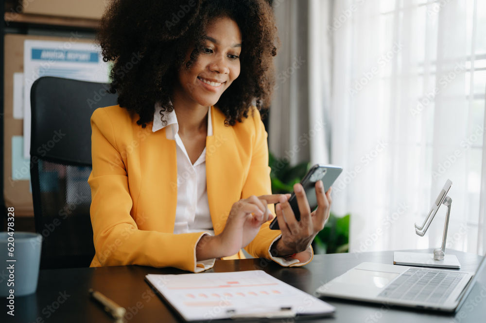 Beautiful African business woman typing laptop and tablet Placed at the ...