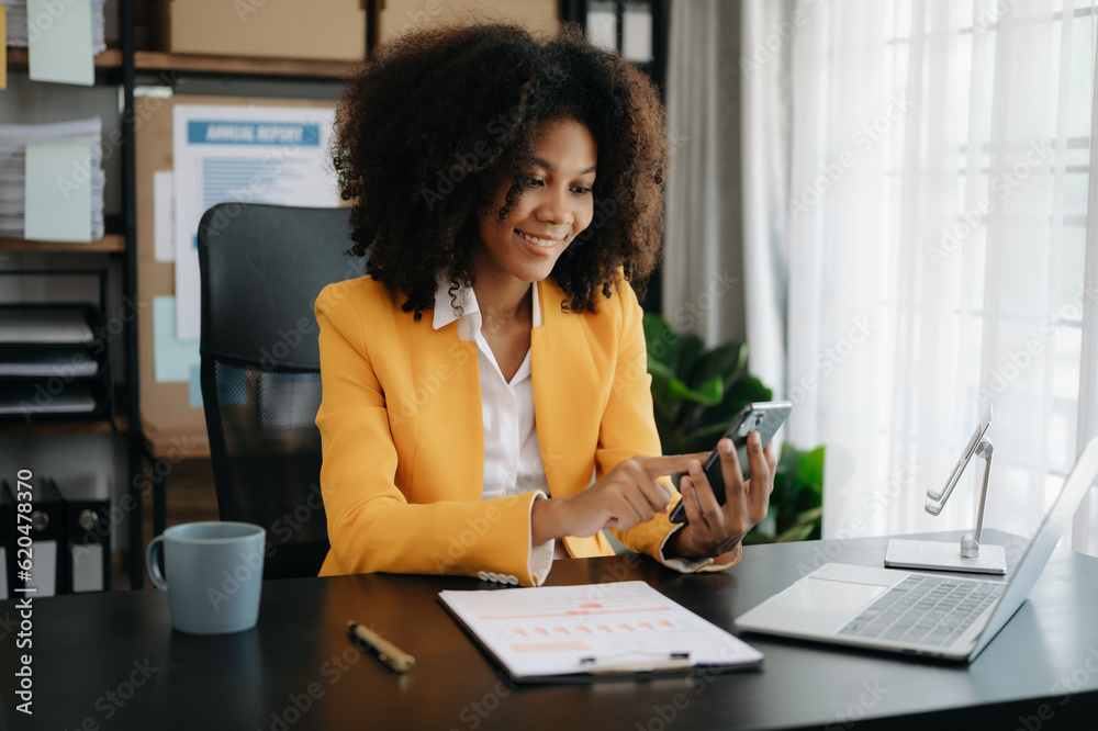 Beautiful African business woman typing laptop and tablet Placed at the ...