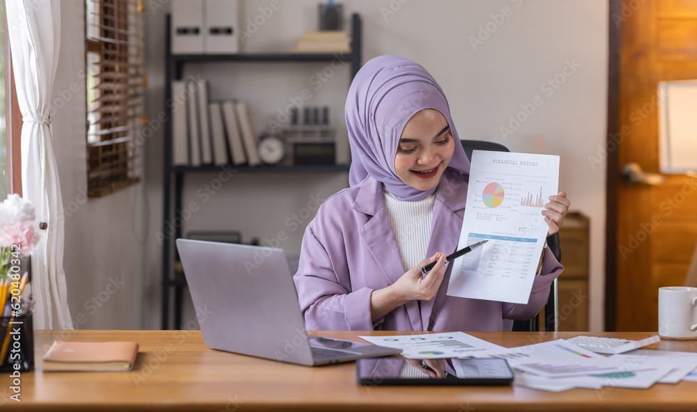 Asian business asian islamic woman in hijab holding financial documents ...