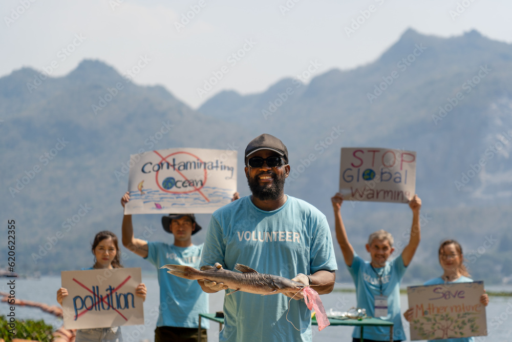 volunteer campaign manager holding dead fish with trash in mouth ...