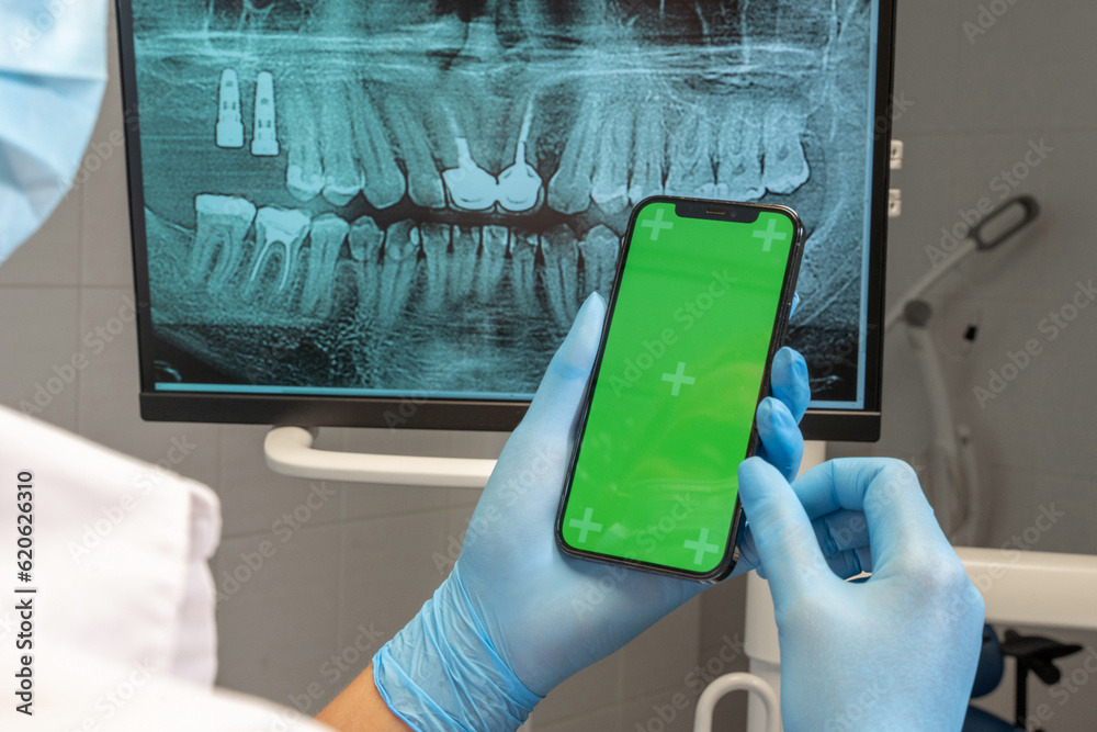 Closeup dentist hands sterile glove hold green screen cellphone at ...