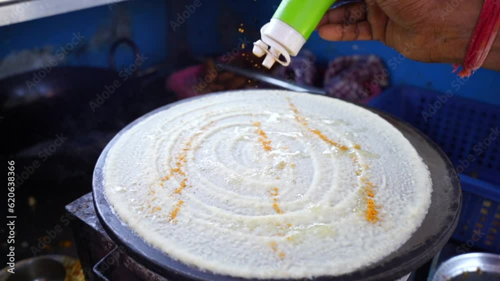 Spread masala on famous Indian food dosa while making dosa on a hot gas ...