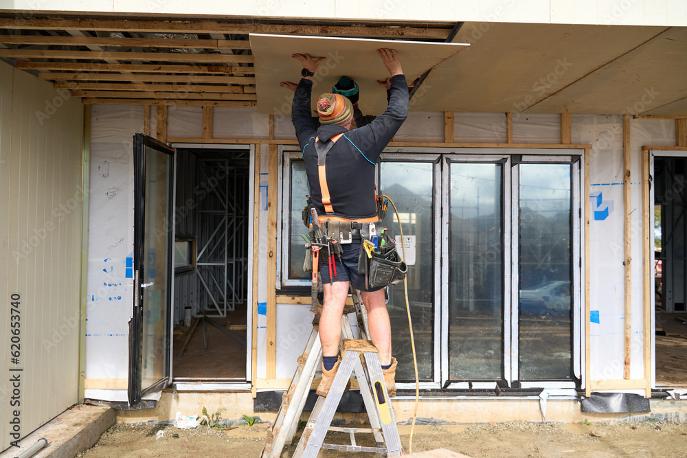 Workers at house build placing cladding Stock Photo | Adobe Stock