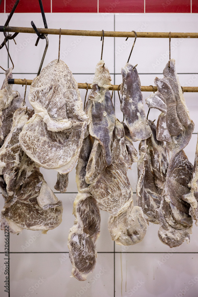 Salted and dry jerked beef hanging from hooks at small family butchery ...