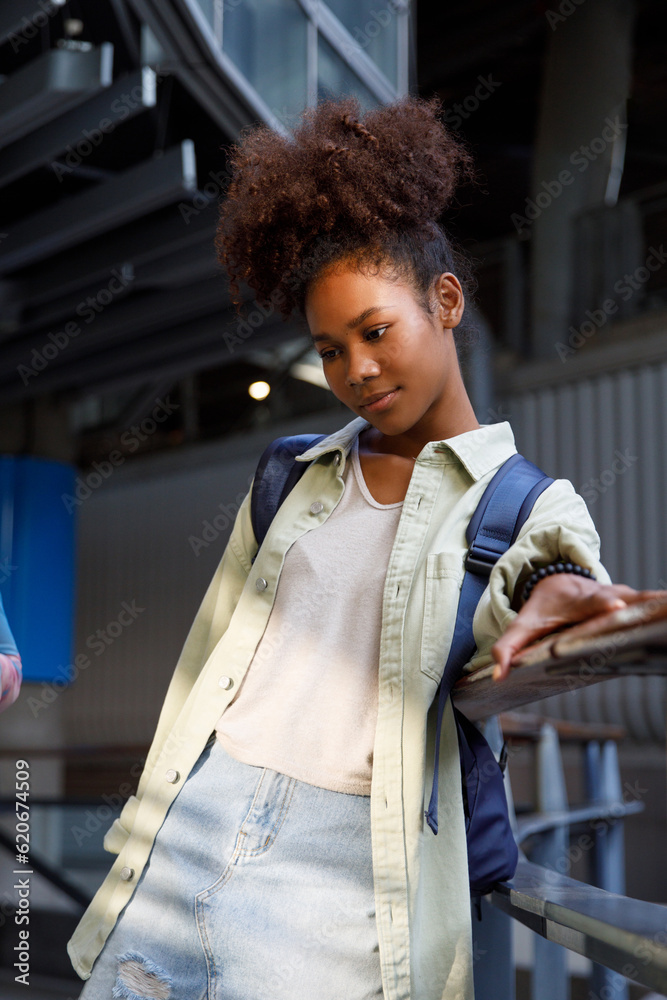 Bored young woman with curly hair leaning outdoor on fence Stock Photo ...