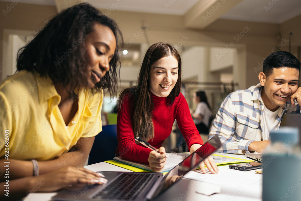 Foto de Students doing work and studying with laptops and notes in the ...