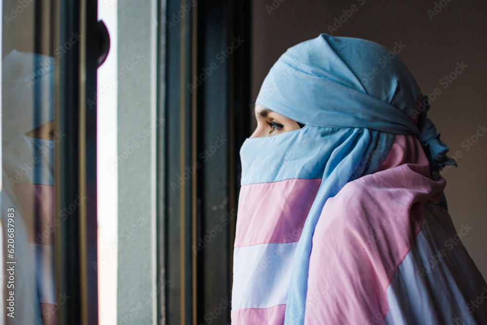 Trans muslim person looking through the window Stock Photo | Adobe Stock