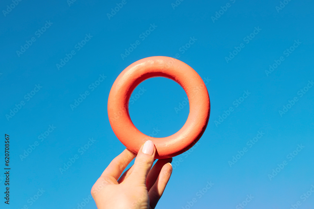 Hand holding a red torus and blue sky background Stock Photo | Adobe Stock