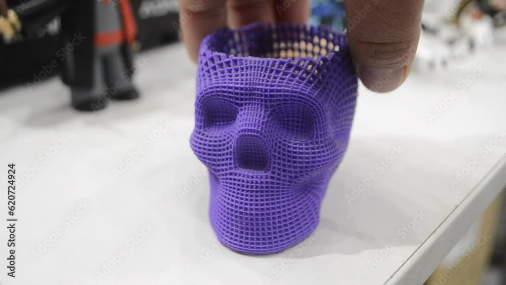 Man rotating prototype 3D printed human skull model made of purple ...