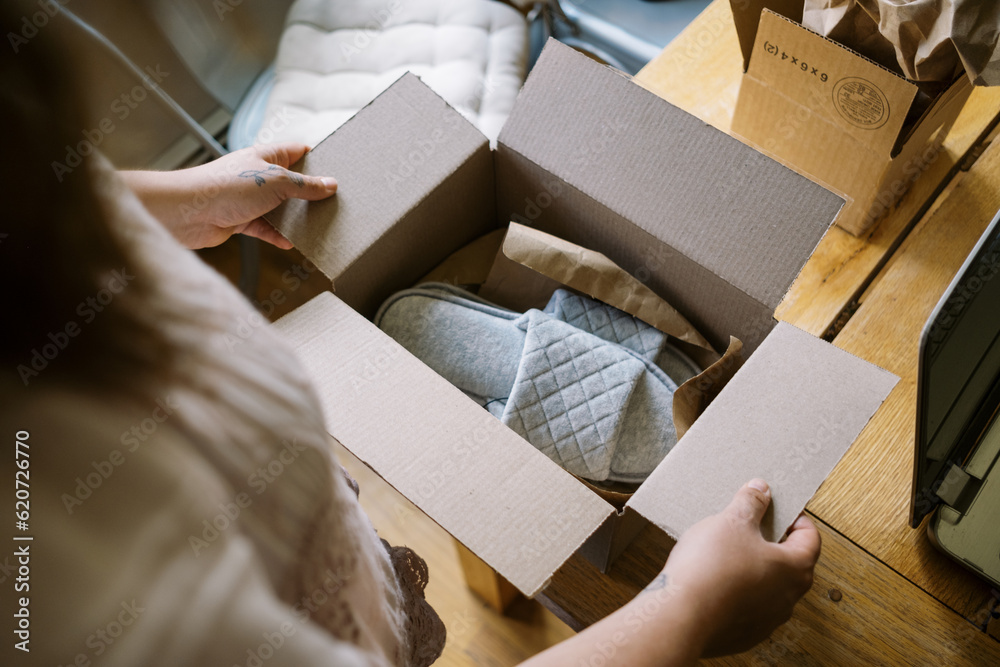 online shopper opening shipping box at home with footwear inside Stock ...