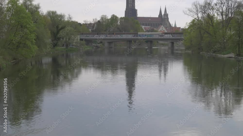 The Danube river reflects the famous landmark of Ulm, the Ulm Minster ...