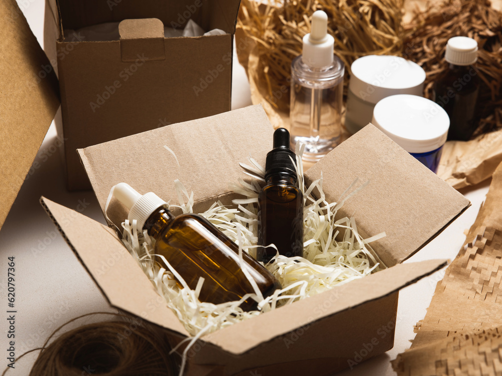 Beauty box with serum bottles on shredded white paper. Eco-friendly ...