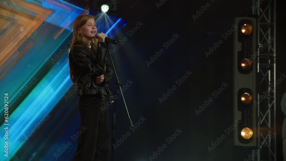 Young teenager girl singer performing on stage, contestant singing ...