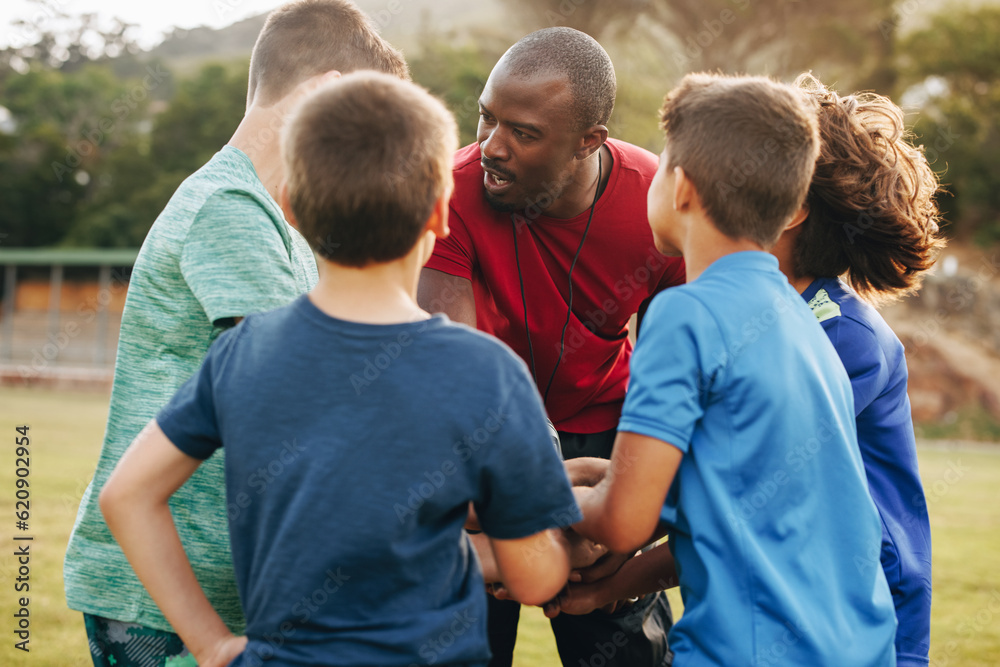 Male coach having a huddle with his school rugby team Stock Photo ...