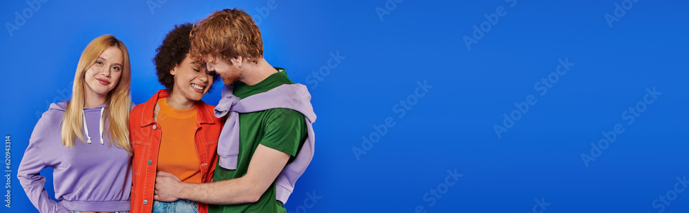 polyamory concept, cheerful redhead man hugging african american woman ...