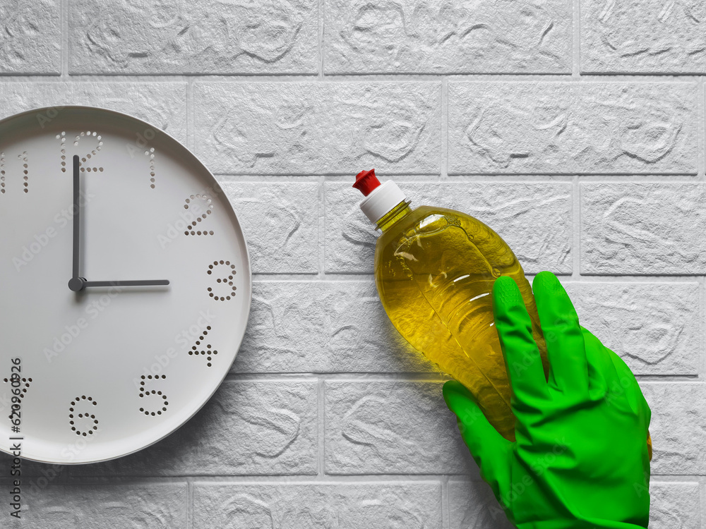 Cleaning time. 3 o'clock, afternoon. hand in rubber glove holds ...