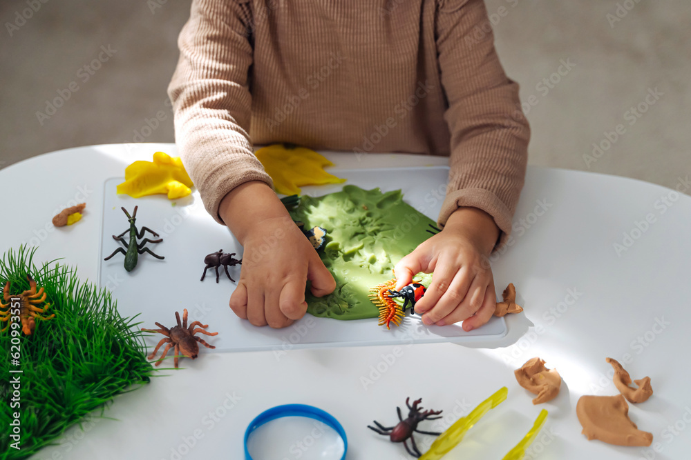 Child hands playing with toy insects. Educational game Bug Fossils made ...
