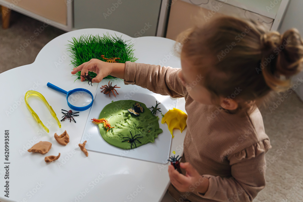 Foto de A little girl playing with toy insects. Educational game Bug ...