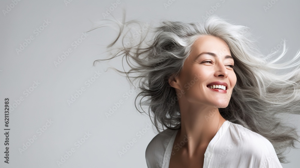 Smiling Mature Woman With Silvery Grey Hair In Front Of A White