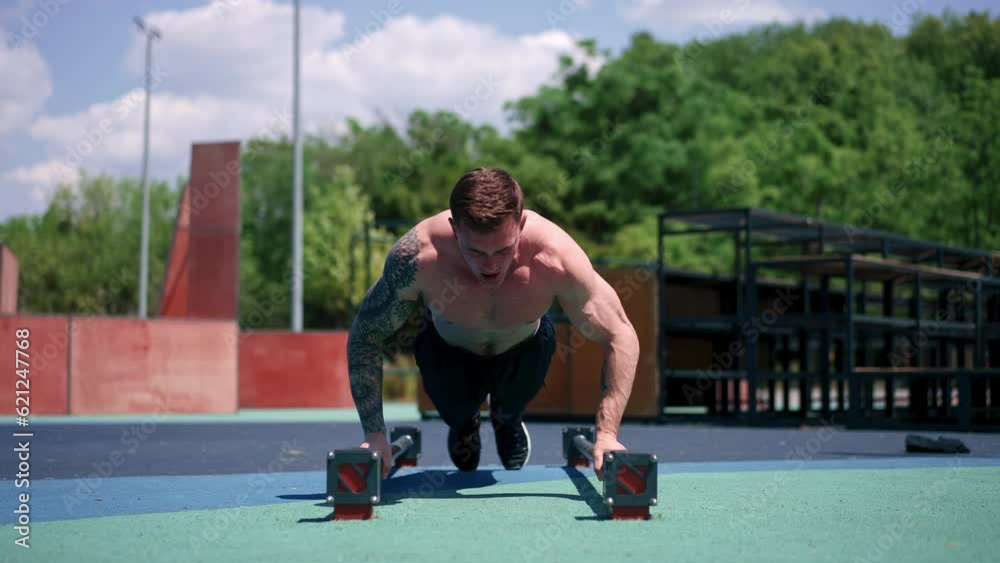 Vidéo Stock young pumped-up athlete doing push-ups from the ground ...