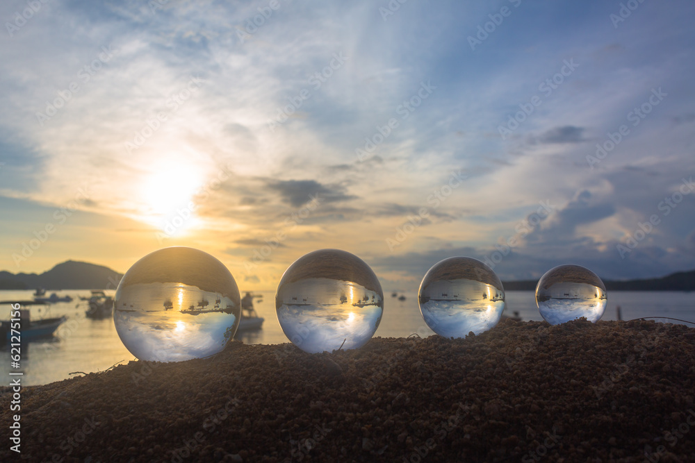 .The 4 glass balls are arranged from large to small placed on the beach ...