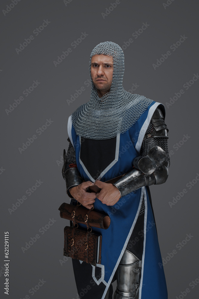 Medieval warrior garbed in shining armor, blue surcoat, and chainmail ...