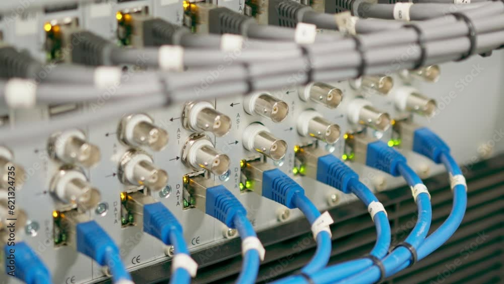 a bunch of patch network cables sorted in a rack cabinet leading from a ...