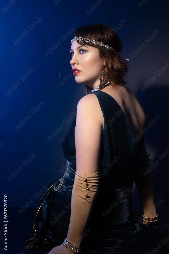 Studio portrait of a caucasian model wearing 1920s retro fashion. She ...