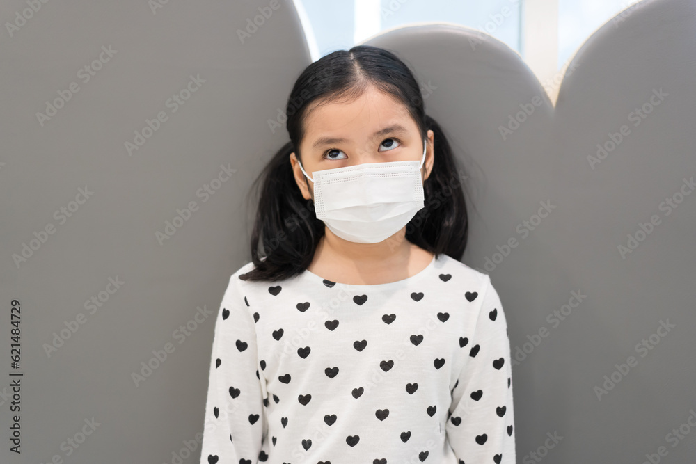 Asian child or kid girl wearing white face mask for close mouth nose to ...