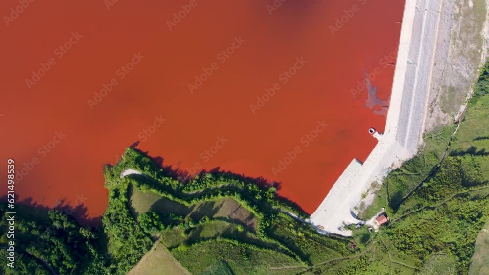 Red lake and green forest. Tailing pond. Dam on Polluted lake in nature ...