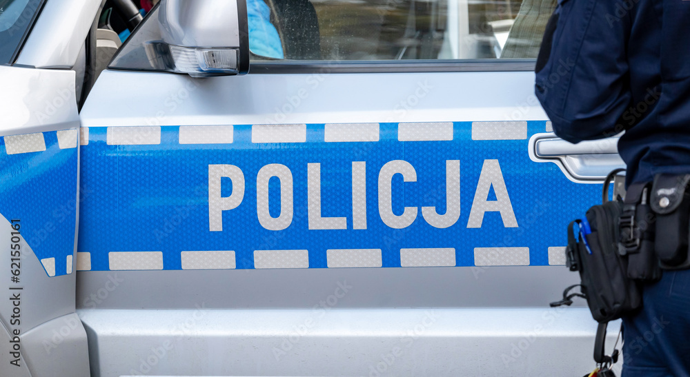 Blue Polish police vehicle and a policeman, policja, police car side ...
