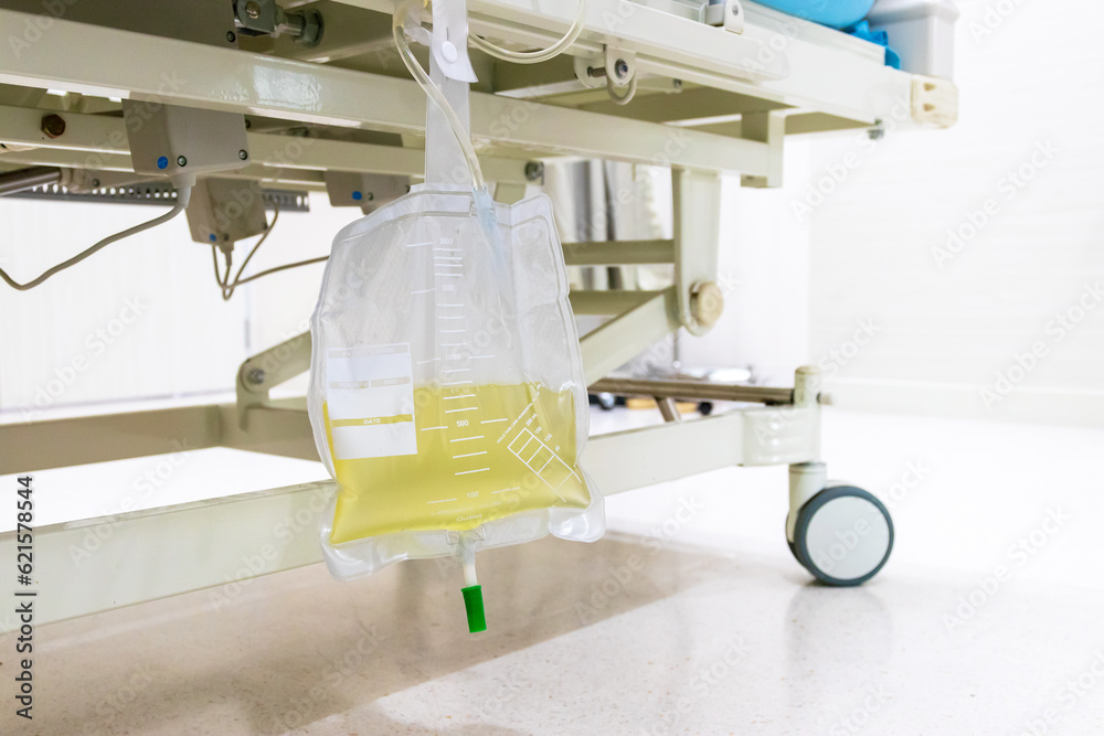 Urine bag hanging under patient bed in room at hospital. The doctor ...
