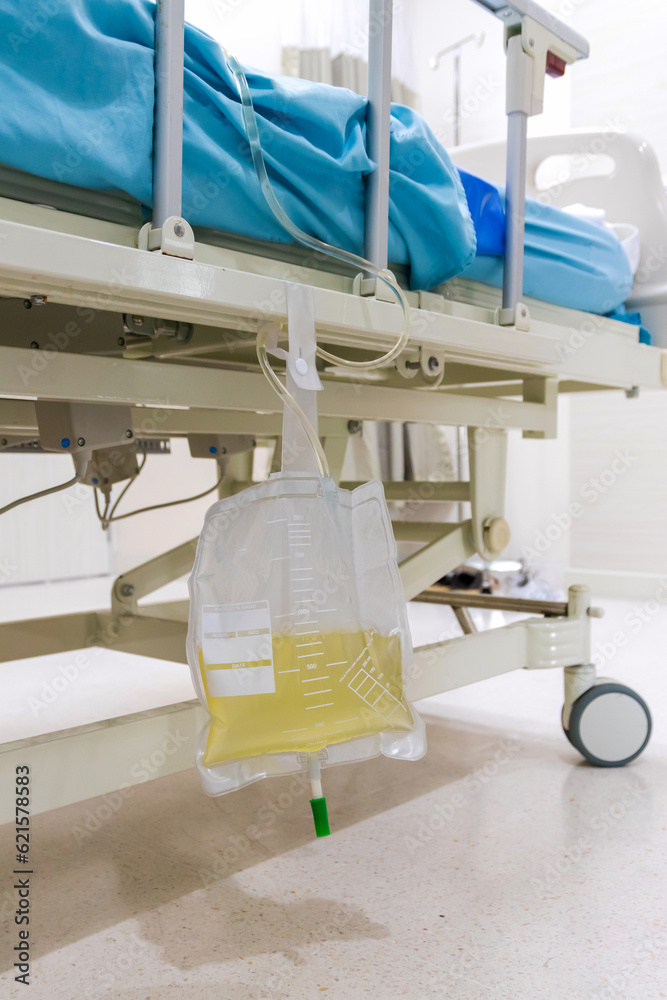 Urine bag hanging under patient bed in room at hospital. The doctor ...