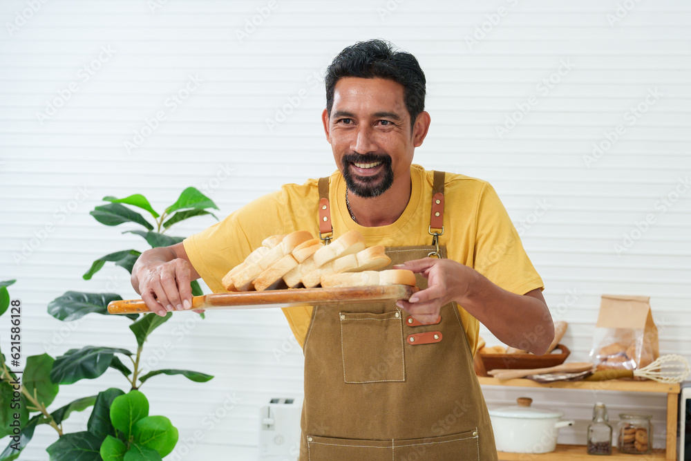 Bearded Asian male video blogger, wearing overalls, holding a tray of ...