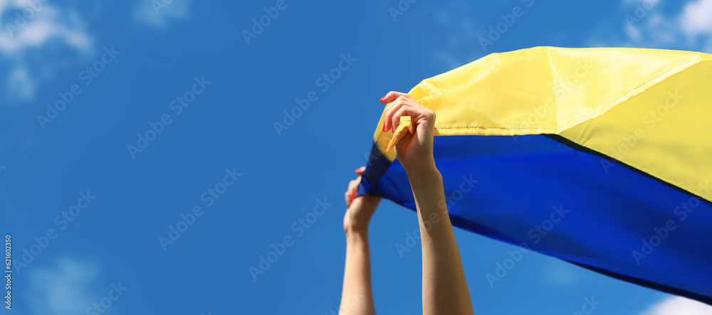 Women's hands with the Ukrainian flag against the sky. Concept: war in ...