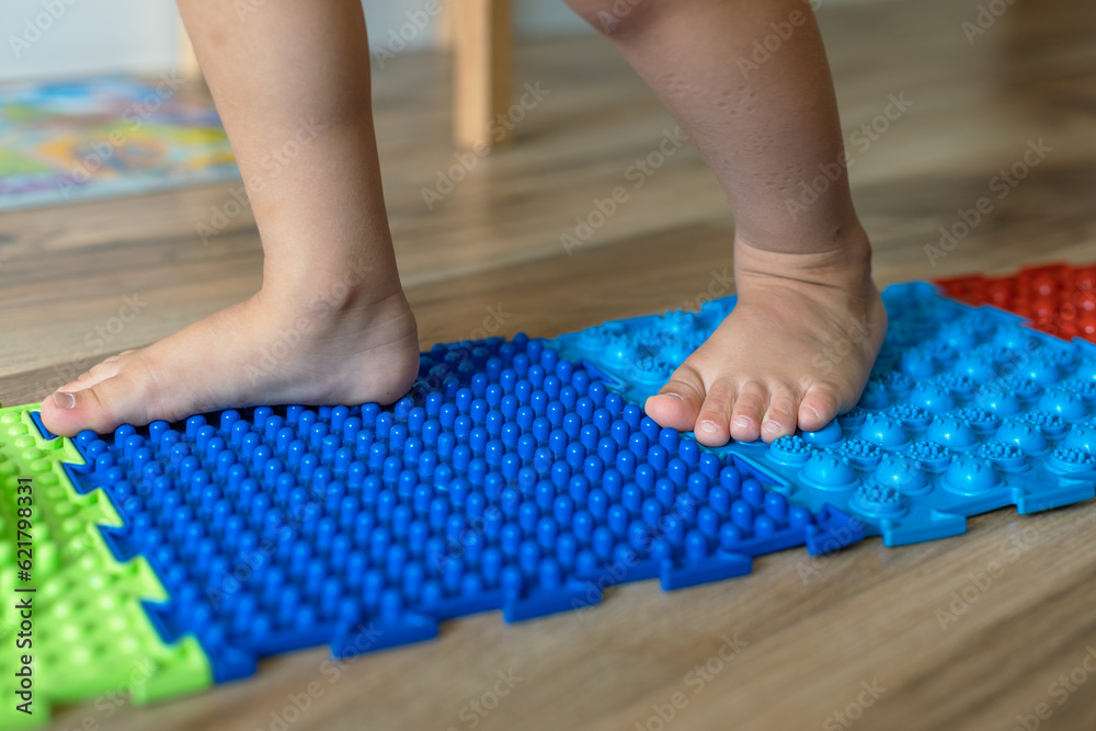 children's feet, stepping on colorful massage mats with different ...