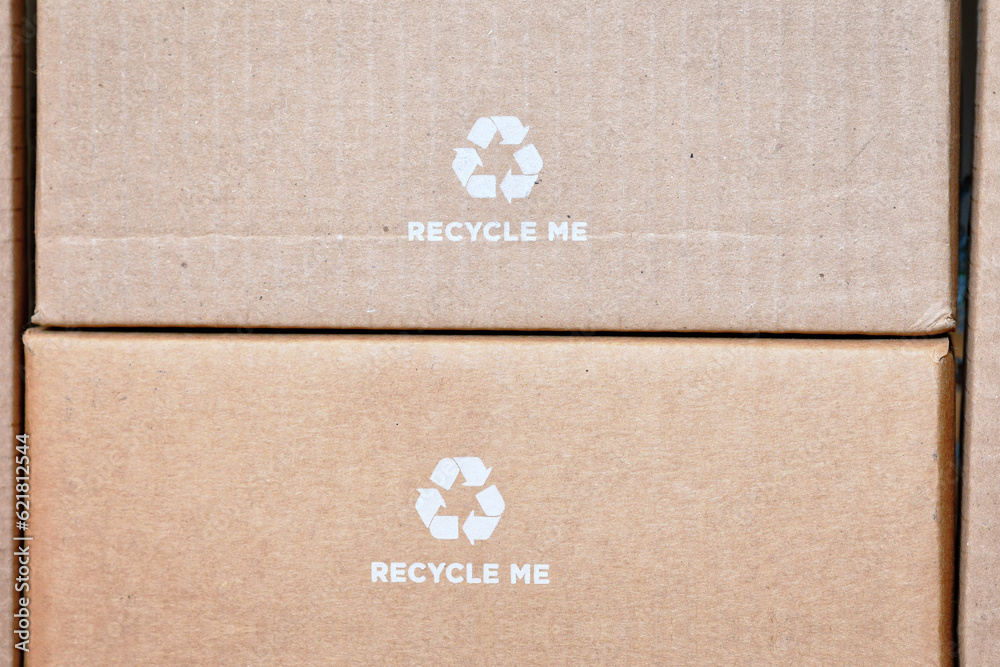 Cardboard boxes with recycling arrow symbol and text saying Recycle me ...