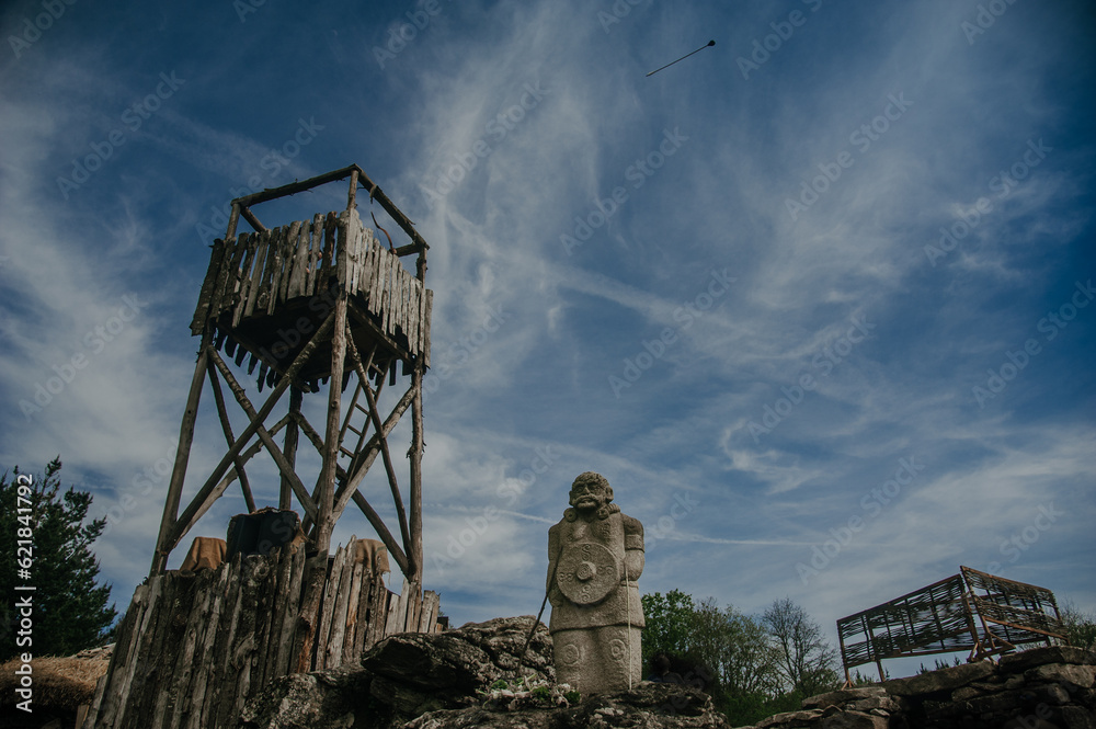 A Roman archer tower with a stone statue and an arrow mid-flight ...