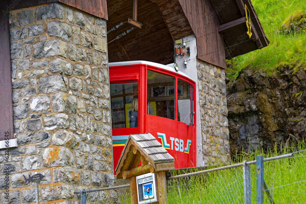 Red train leaving valley station of cable car Treib Seelisberg at ...