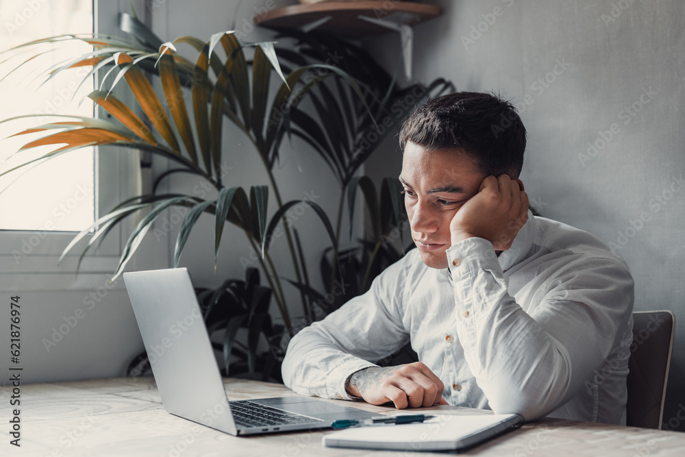 Tired male student or worker sit at home office desk look in distance ...