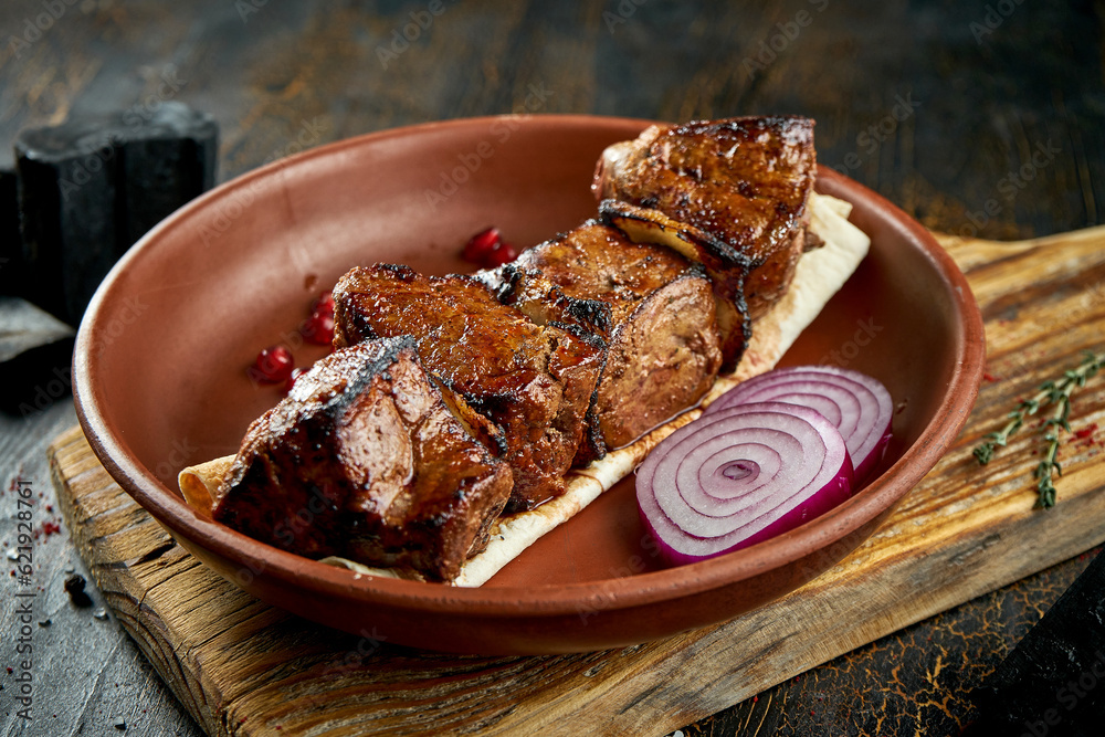 Beef liver roasted on a barbecue and charcoal, in a plate. Shish kebab ...