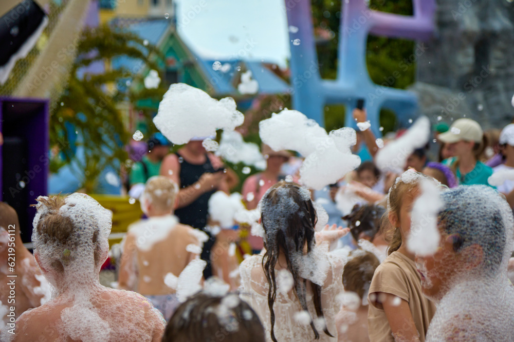 Crowd of adults and children dance to the music at a foamy party at the ...